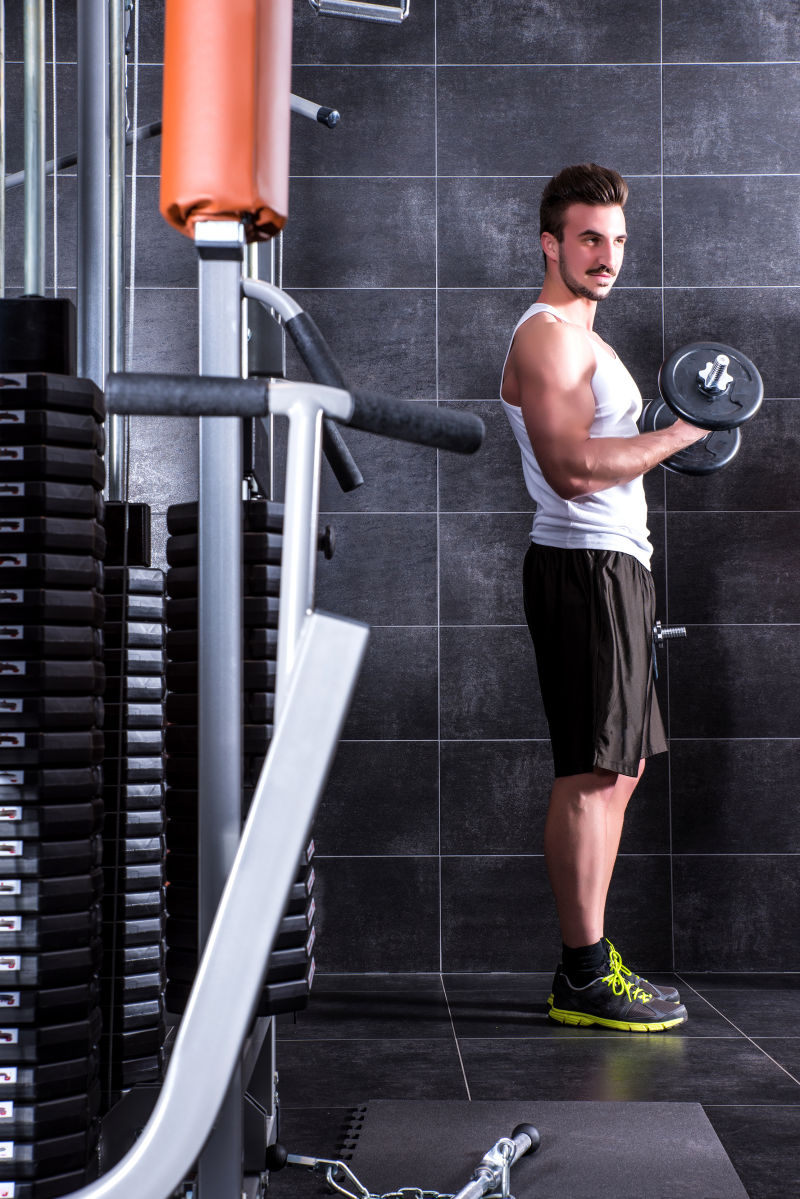 一个年轻的女士在健身教练指导下健身图片-健身房里带着私人男教练的美女素材-高清图片-摄影照片-寻图免费打包下载