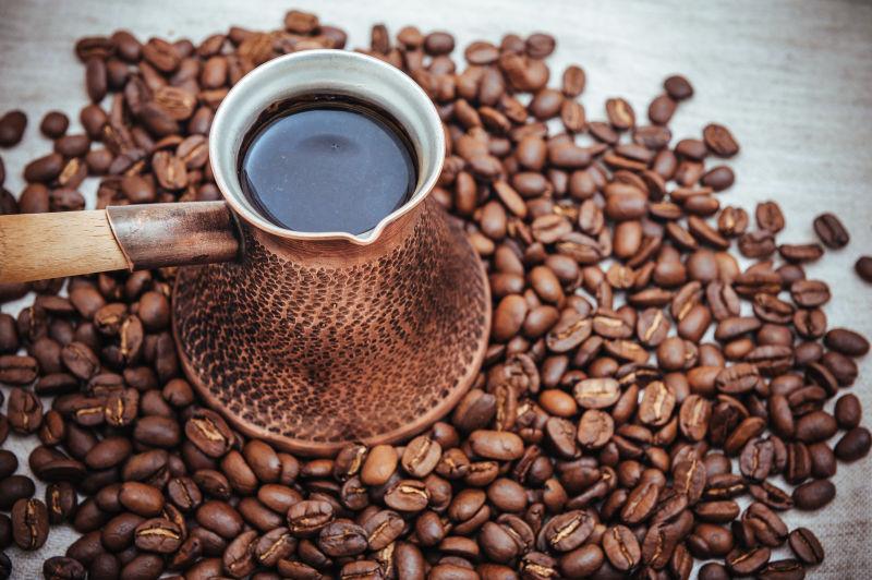 杯中咖啡和咖啡豆图片-深褐色背景的杯中咖啡和咖啡豆素材-高清图片-摄影照片-寻图免费打包下载